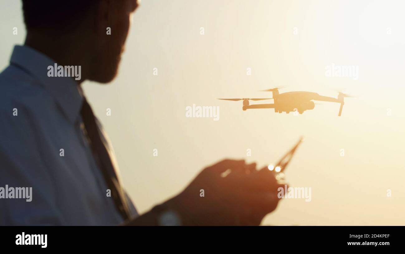 Male holding controller operating drone Stock Photo - Alamy