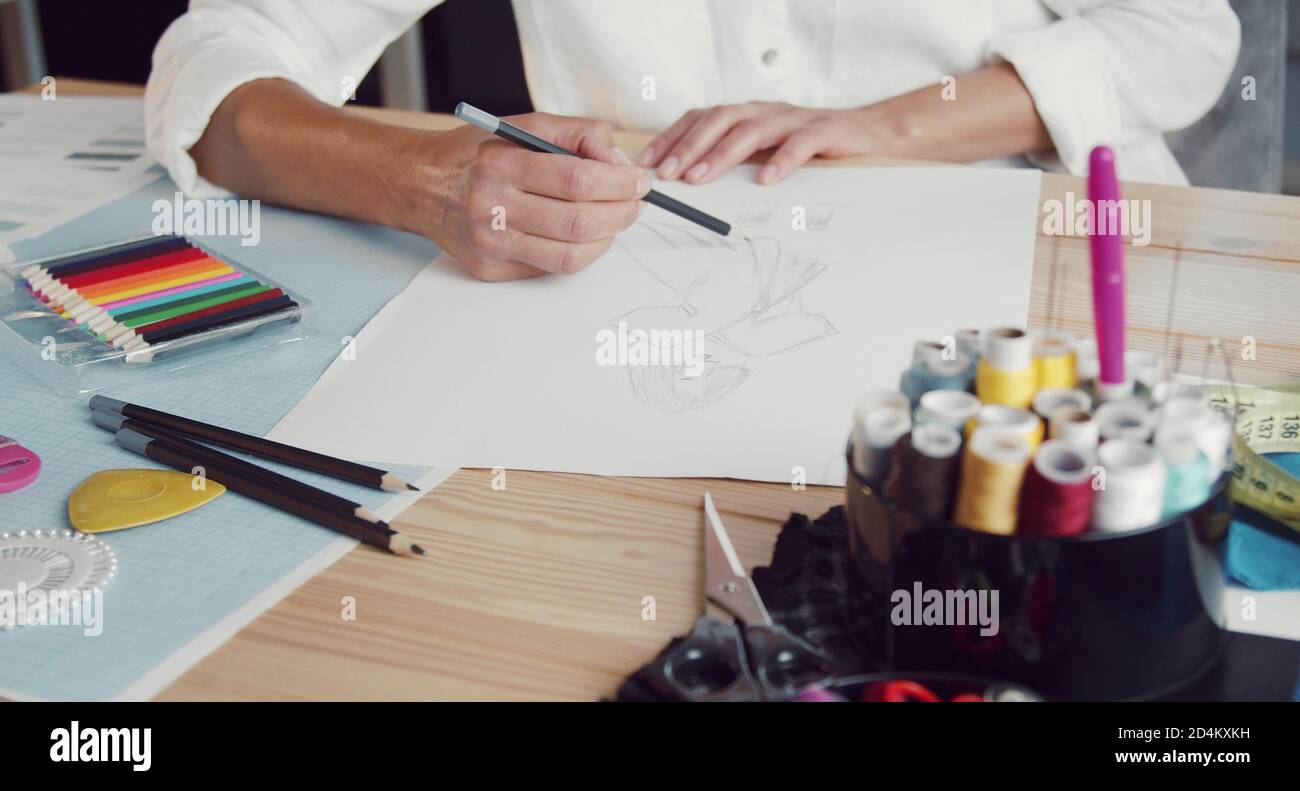 Fashion designer hands drawing sketch Stock Photo - Alamy