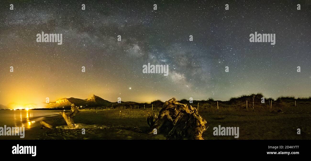 ld trunk stranded on the beach of Son Serra de Marina, a starry night ...