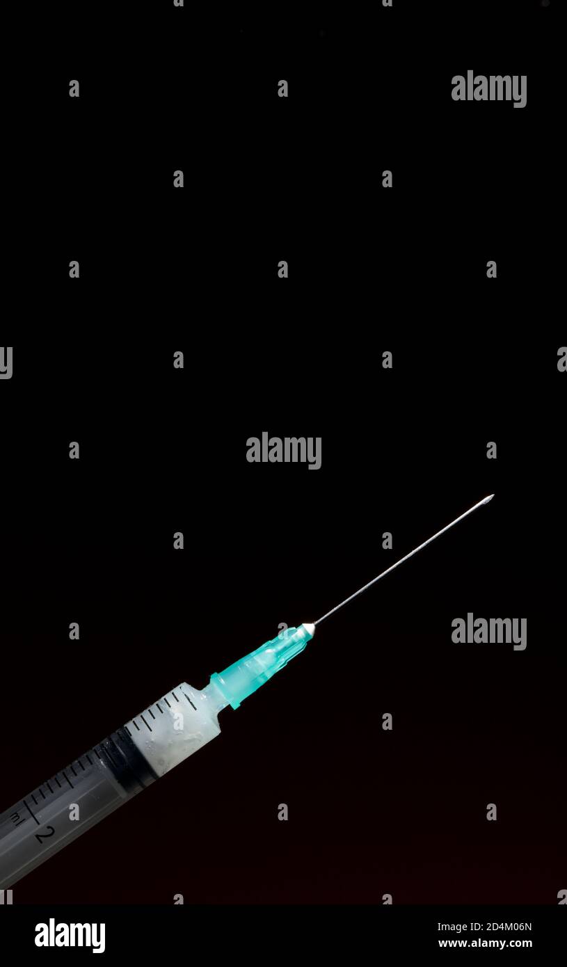 Closed syringe isolated on black background Stock Photo - Alamy