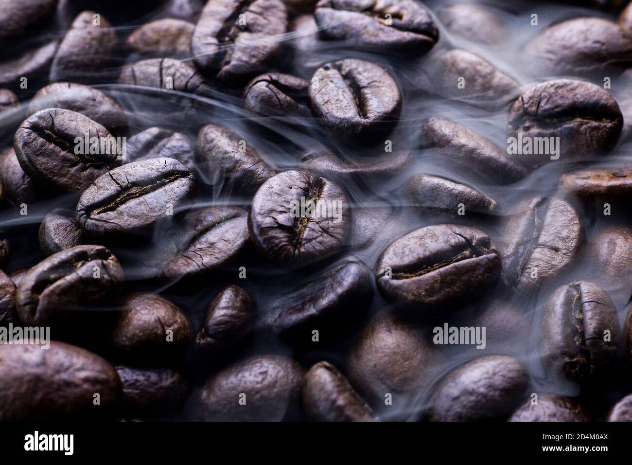 Fresh roasted coffee beans with smoke. Brown roasted coffee beans ...