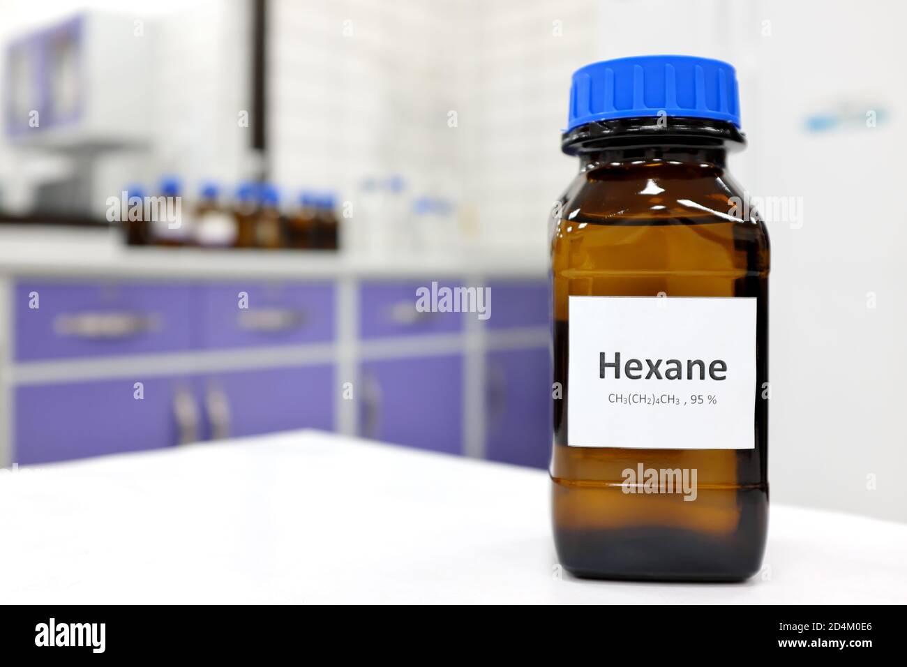 Selective focus of hexane liquid chemical compound in dark glass bottle ...