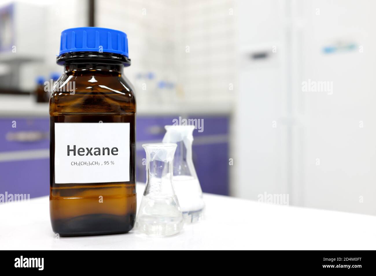 Selective focus of hexane liquid chemical compound in dark glass bottle ...