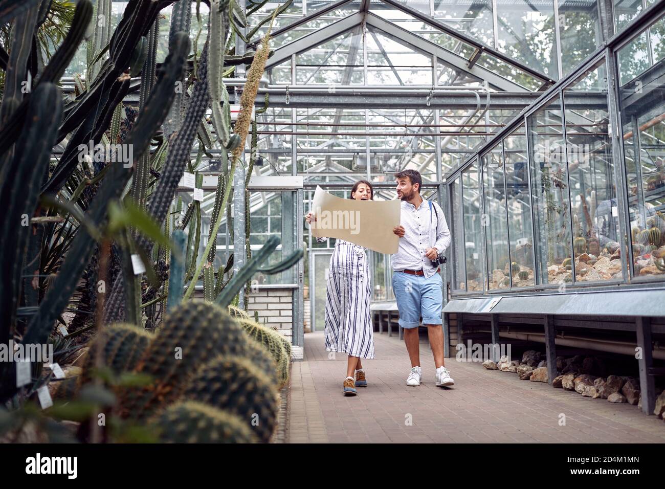 Young colleagues walking guided by the map through a beautiful ...