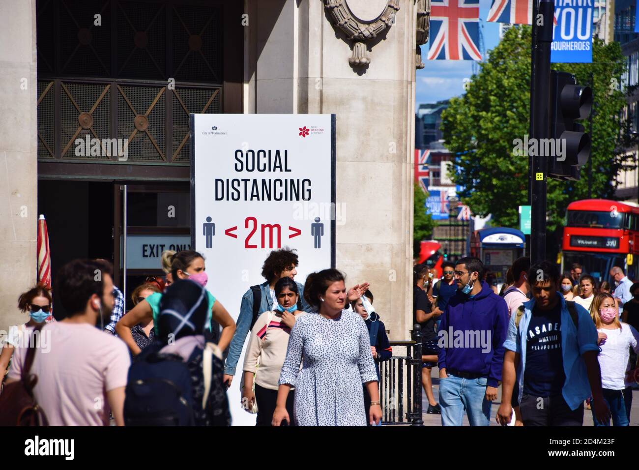 Crowd of people next to a Social Distancing sign on Oxford Street ...