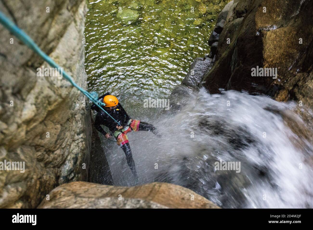 High angle view of man rappelling in down waterfall, West Vancouver ...