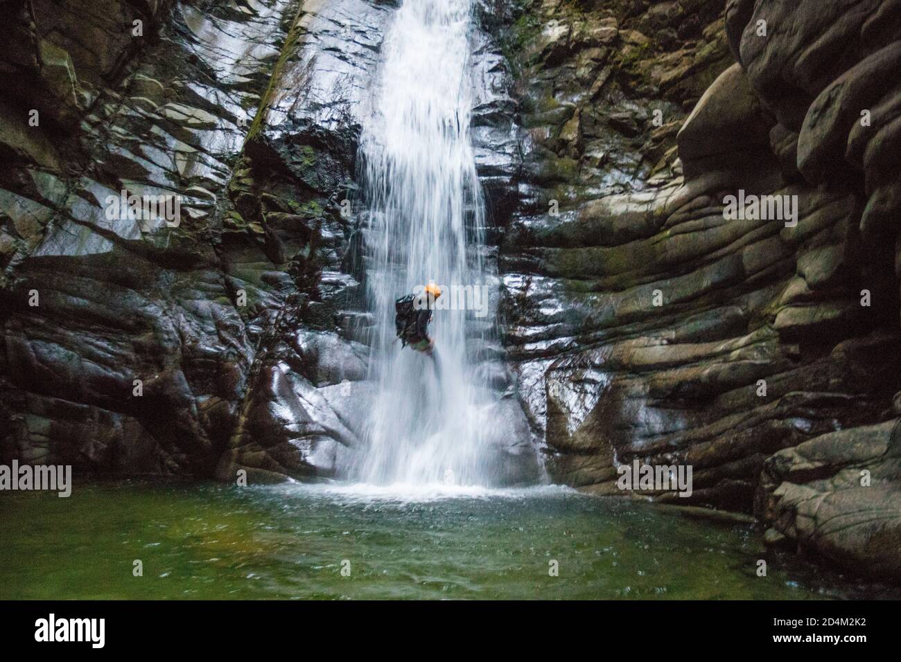 Man rappelling down waterfall approaches deep pool, Vancouver B.C Stock ...