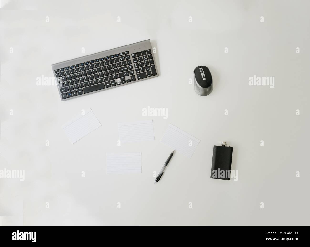 keyboard, mouse, index cards, pen, and flask on white desk Stock Photo ...