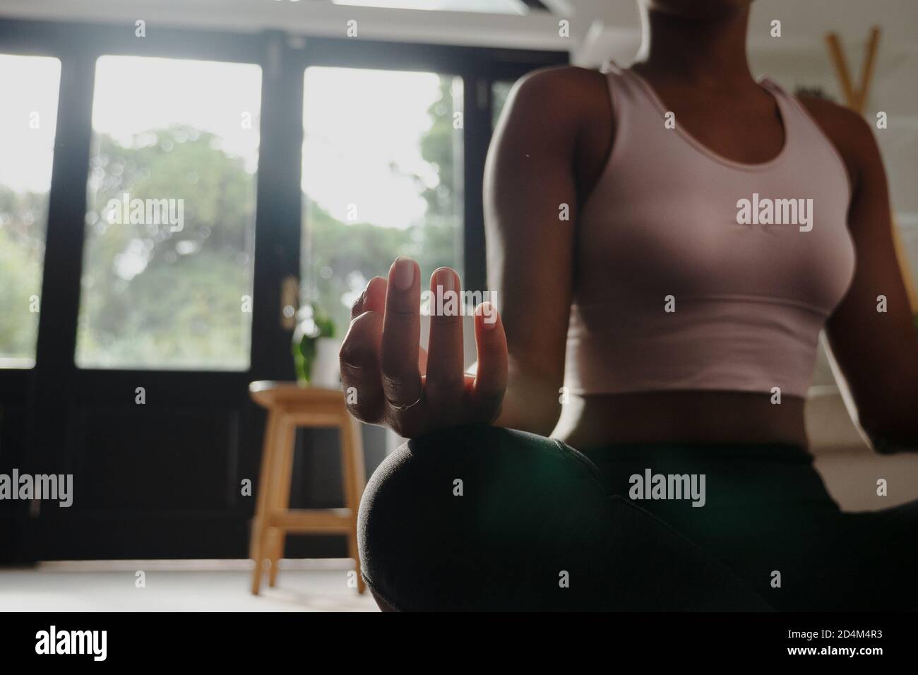Young female yogi in calm position sitting on gym mat in modern lounge ...