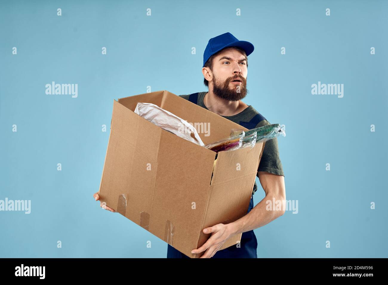 A man in working uniform with boxes in the hands of a carriage delivery ...