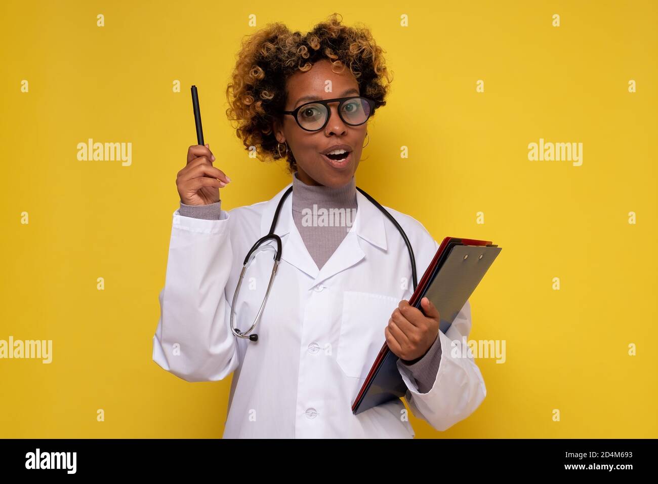 Young female african american doctor pointing finger upwards giving ...