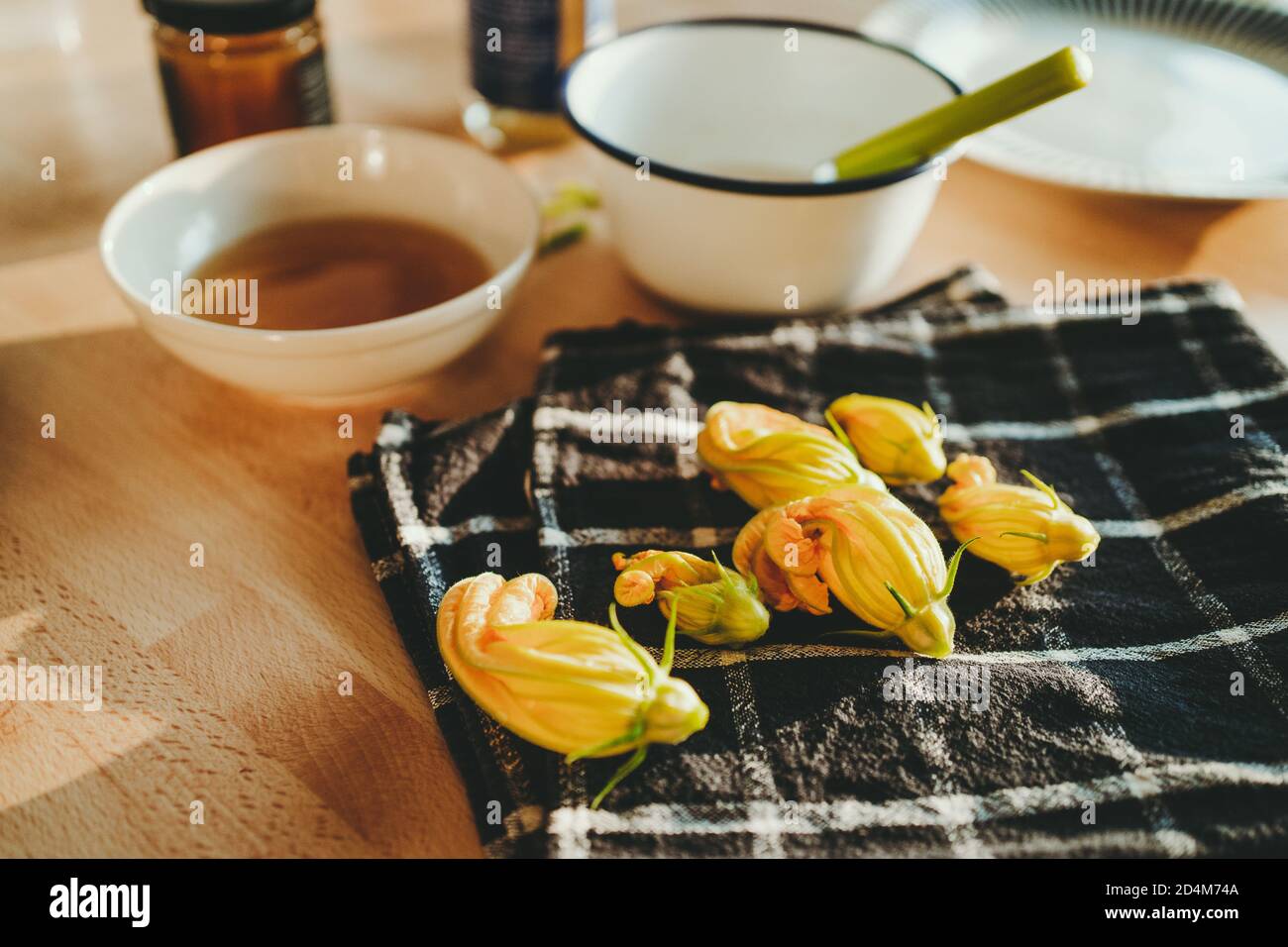 Courgette flowers on a kitchen top with bowls in the background Stock ...
