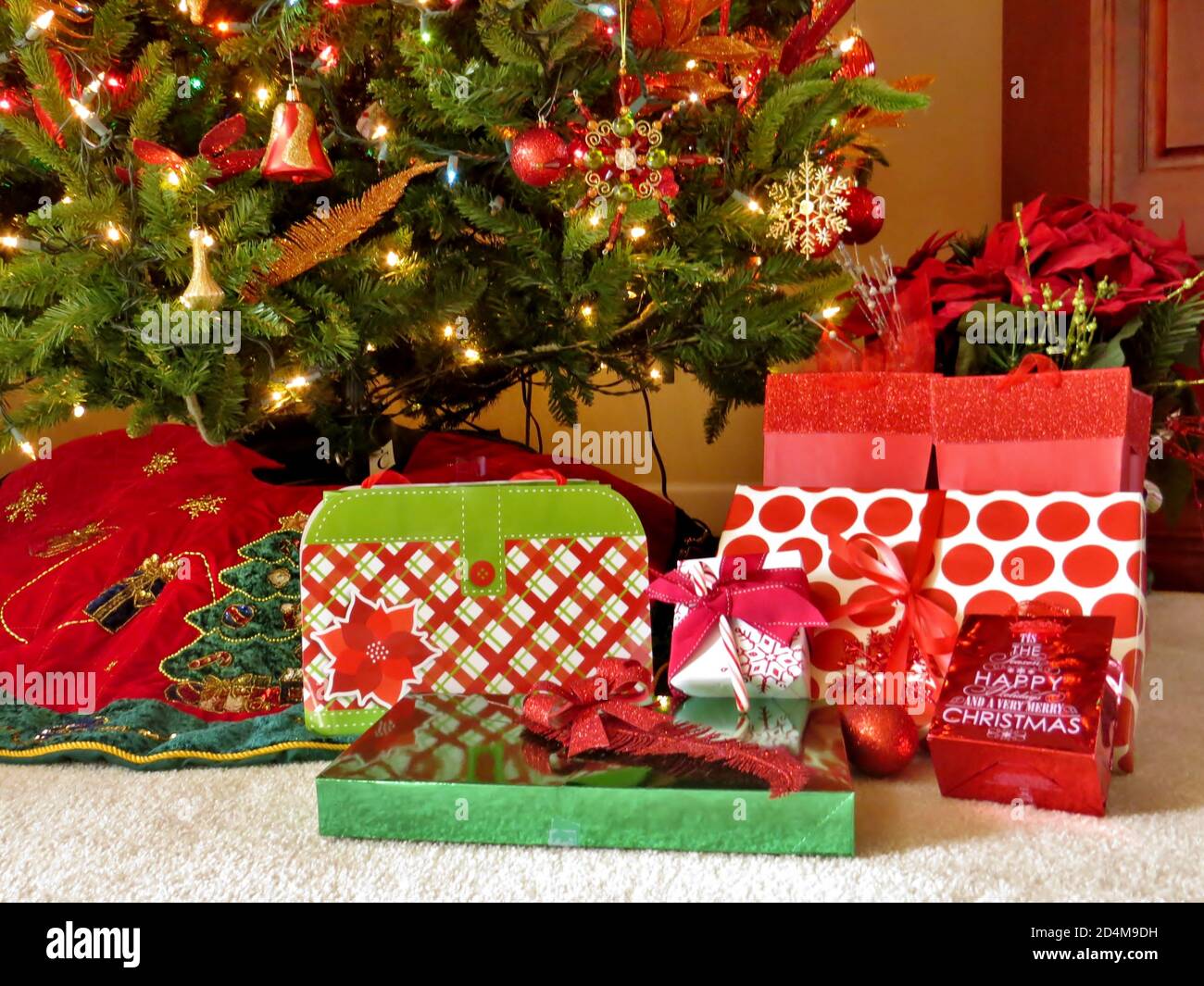Christmas gifts wrapped in festive paper under a decorated tree Stock ...
