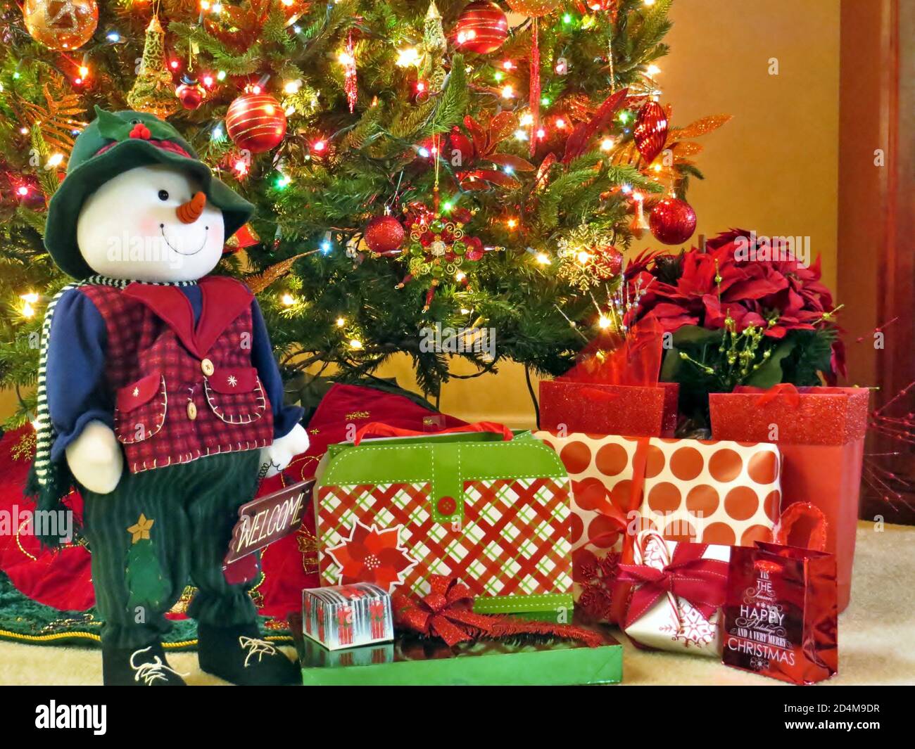 Christmas gifts wrapped in festive paper under a decorated tree Stock ...