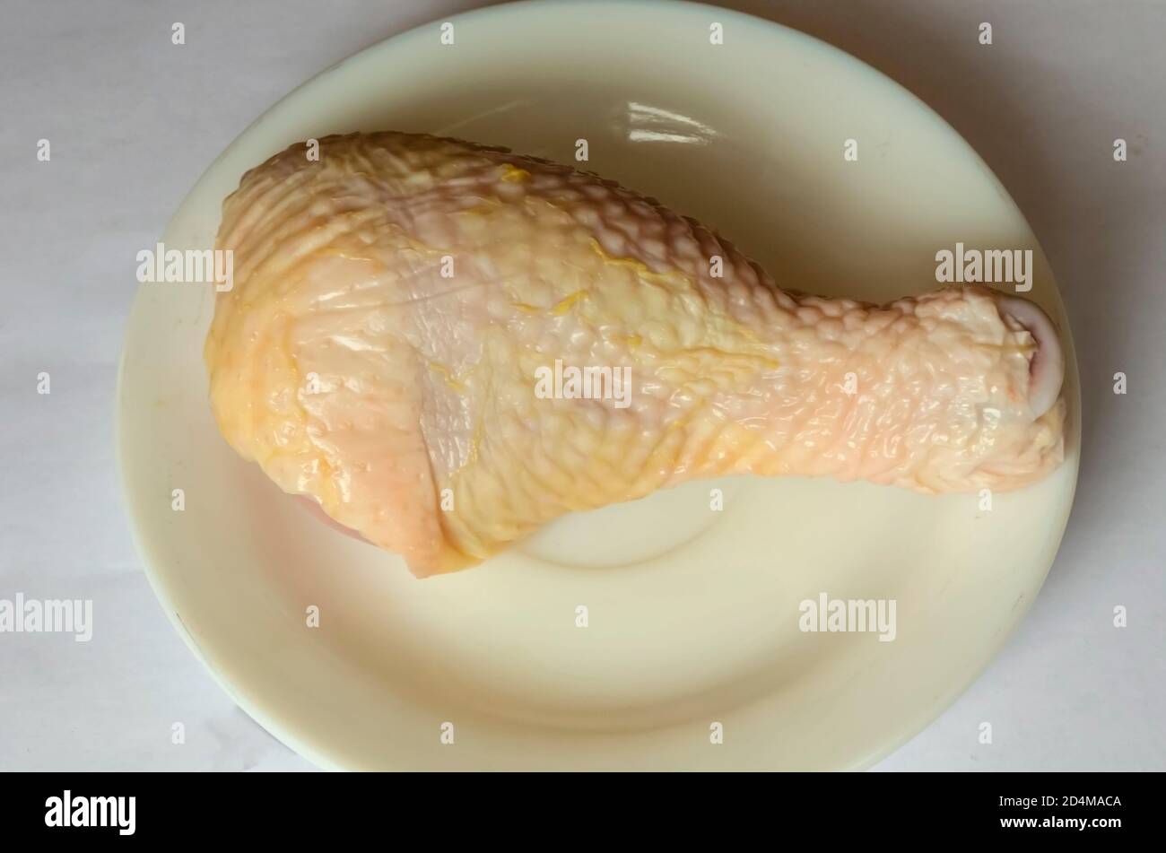 Uncooked Chicken Leg In Small Plate Stock Photo - Alamy