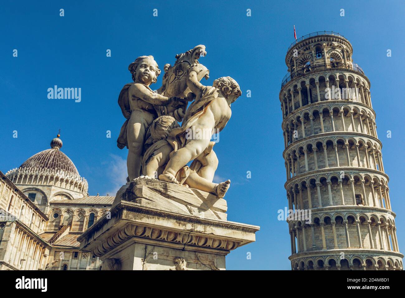 The leaning tower of pisa and cathedral at daytime. Statue with angels ...
