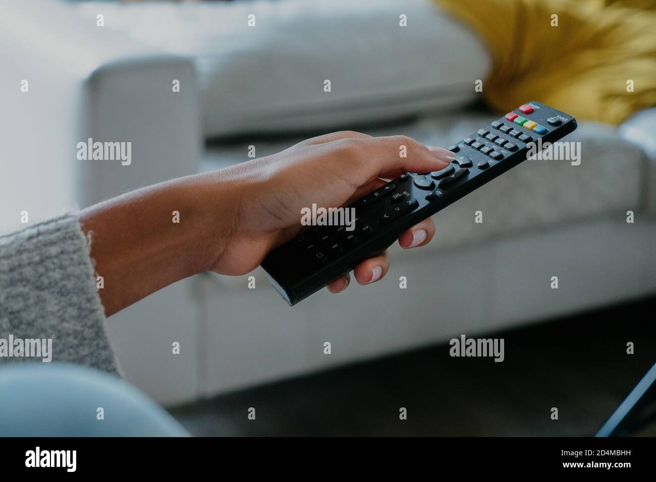 Elegant mixed race female changing television channels with smart ...