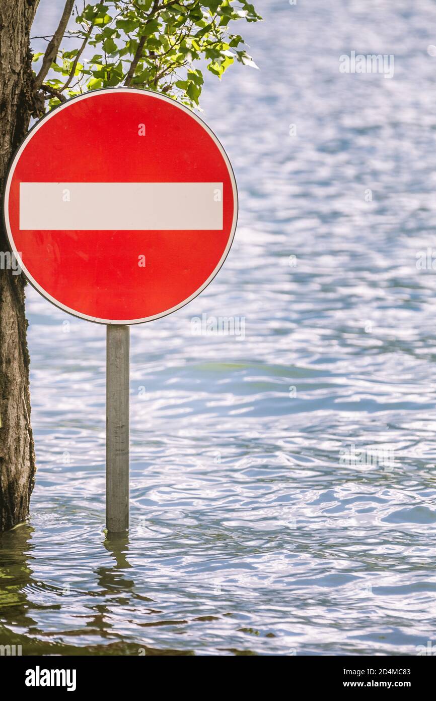 Access prohibition road sign partially submerged in a flood. red disk ...