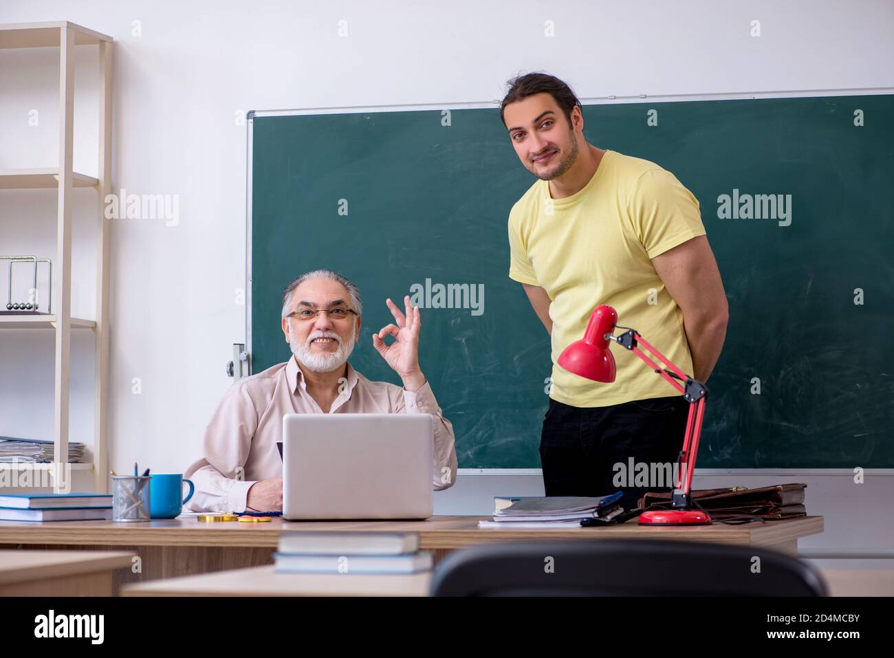 Old teacher and young student in the classroom Stock Photo - Alamy