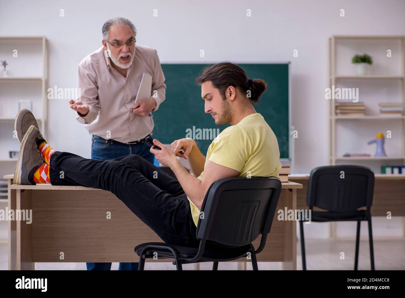 Old teacher and young student in the classroom Stock Photo - Alamy