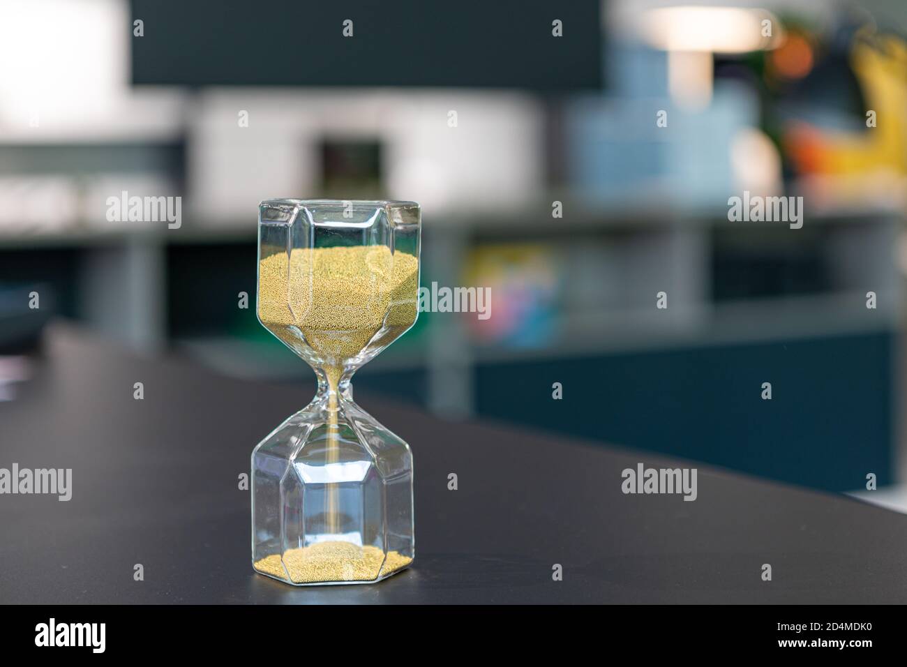 on table stand an egg timer made of glass, which is filled with small ...