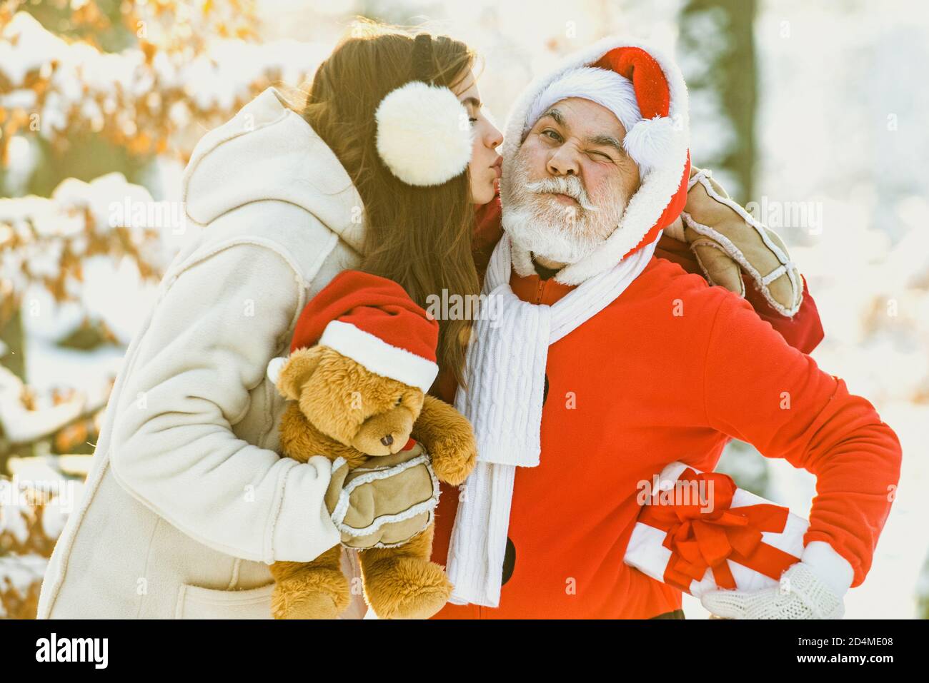 Beauty girl kiss Santa. Santa Claus with girl. Winter landscape of ...