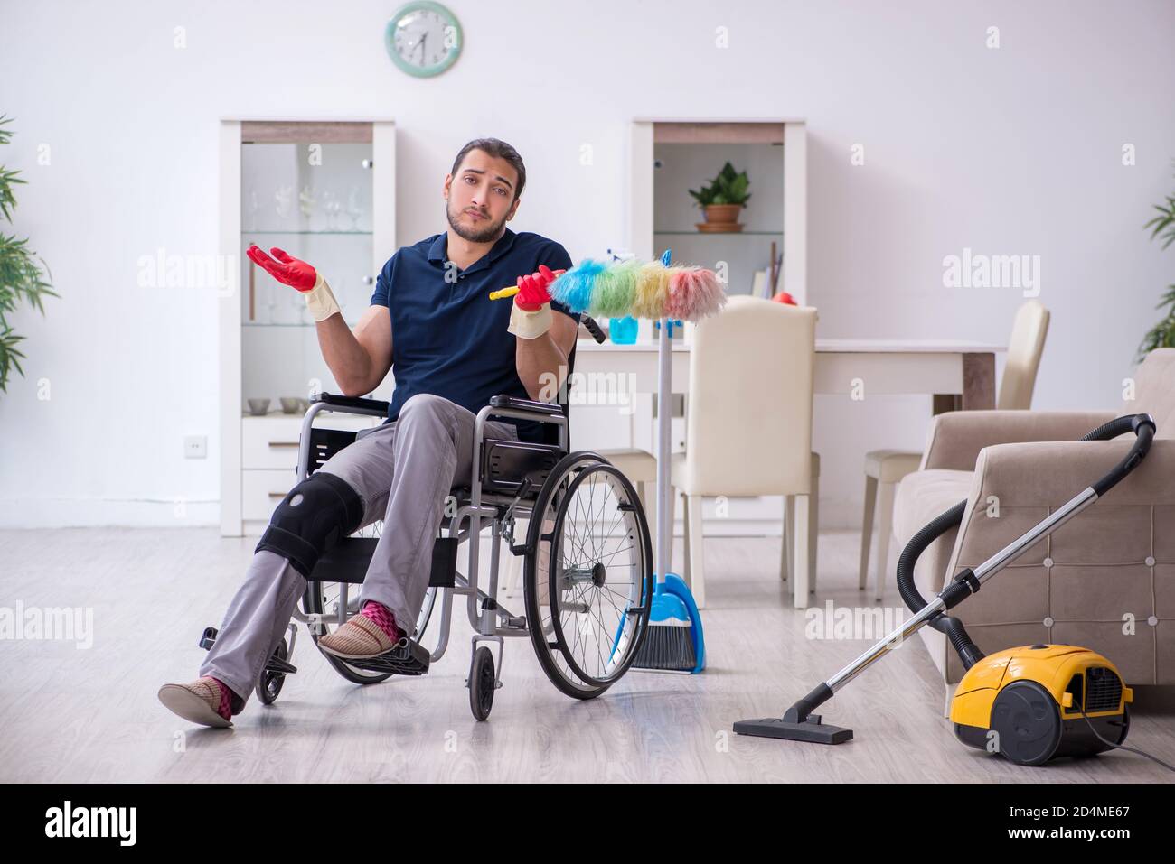 Young leg injured contractor in wheelchair cleaning the house Stock ...