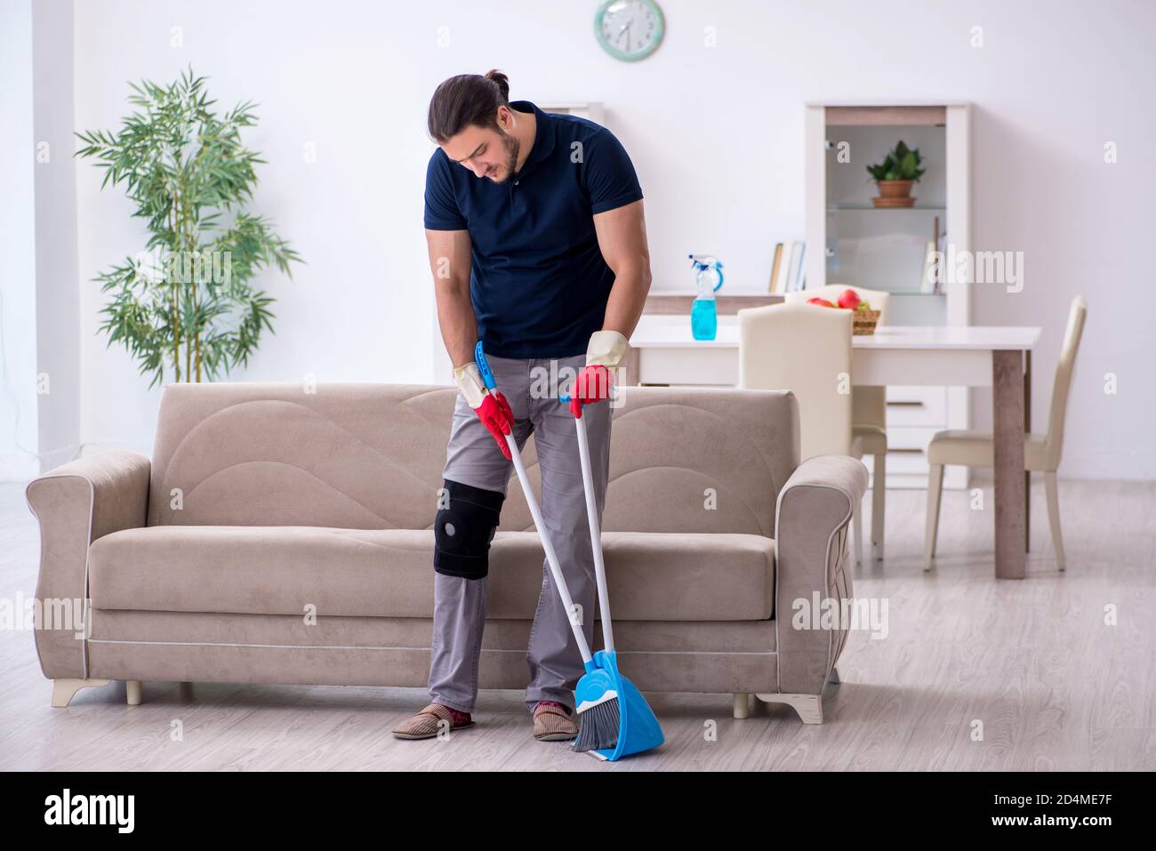 Young leg injured contractor cleaning house Stock Photo - Alamy