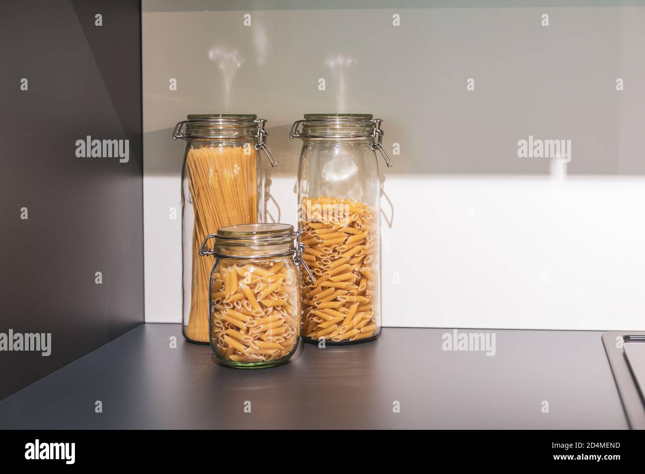 three different sized containers filled with different types of pasta ...