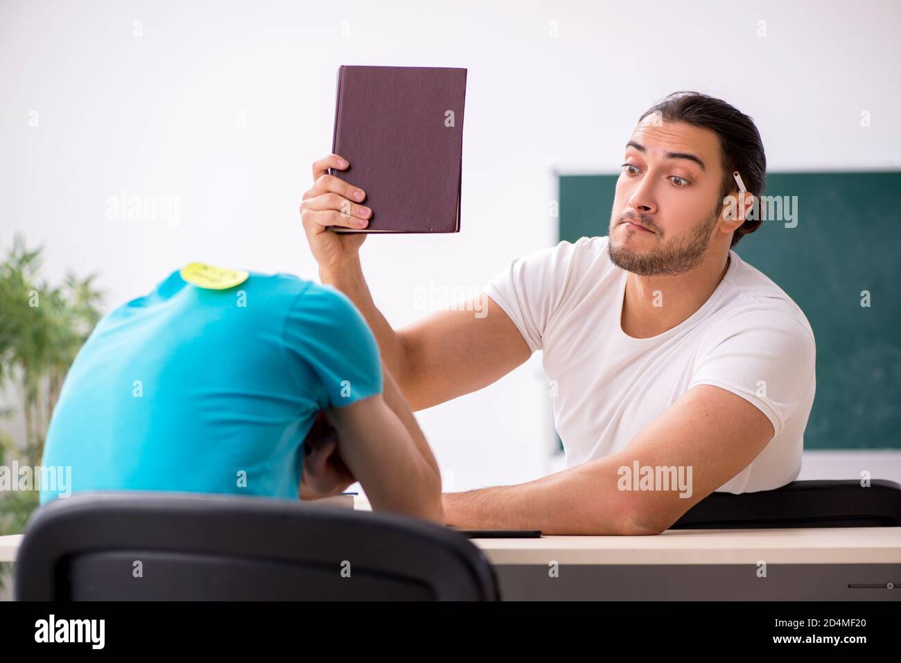 Male pupils in bullying concept in the classroom Stock Photo - Alamy