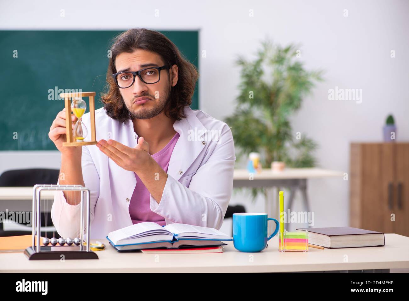 Young physicist teacher in time management concept Stock Photo - Alamy