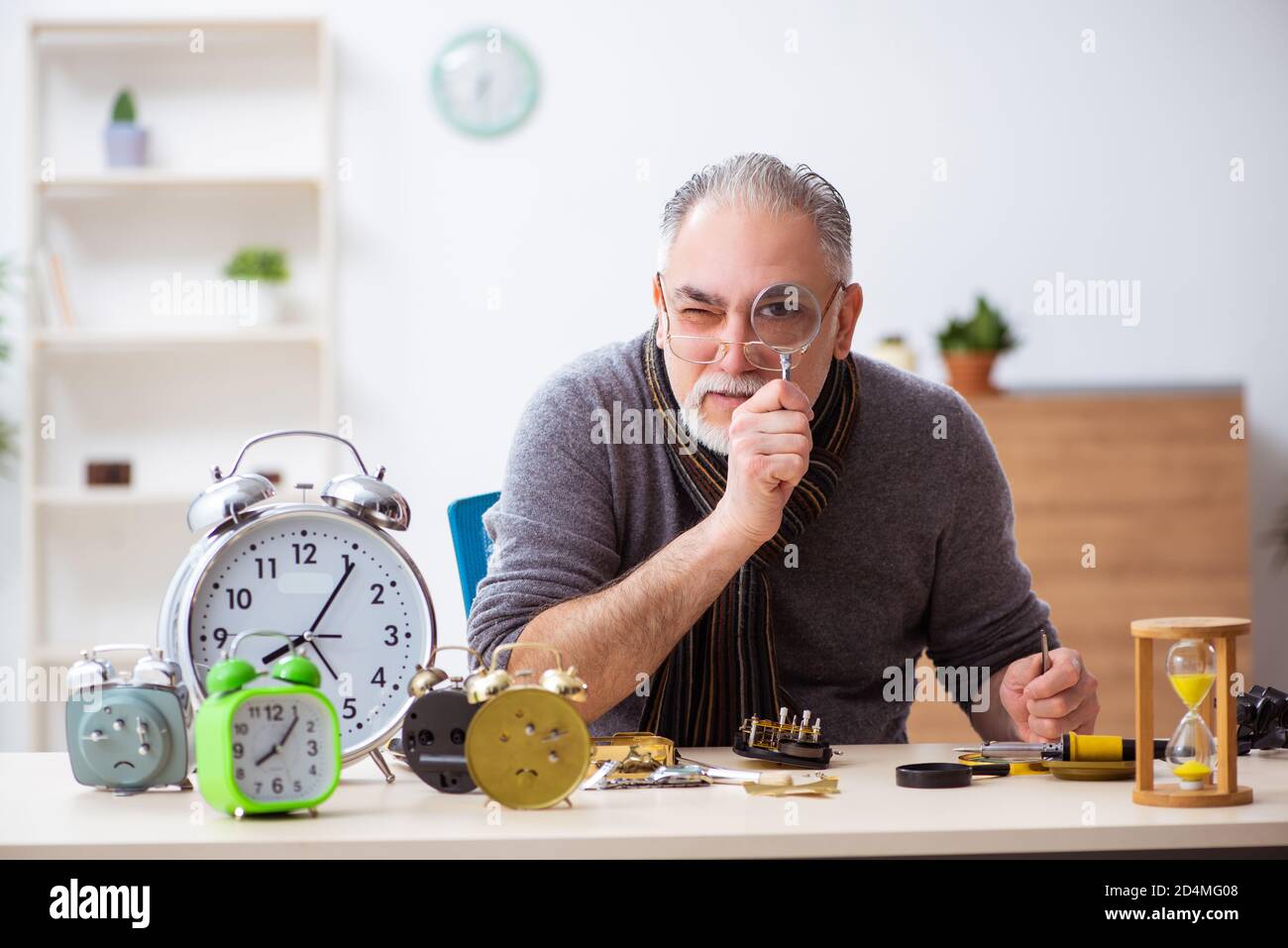 Old watchmaker working in the workshop Stock Photo - Alamy