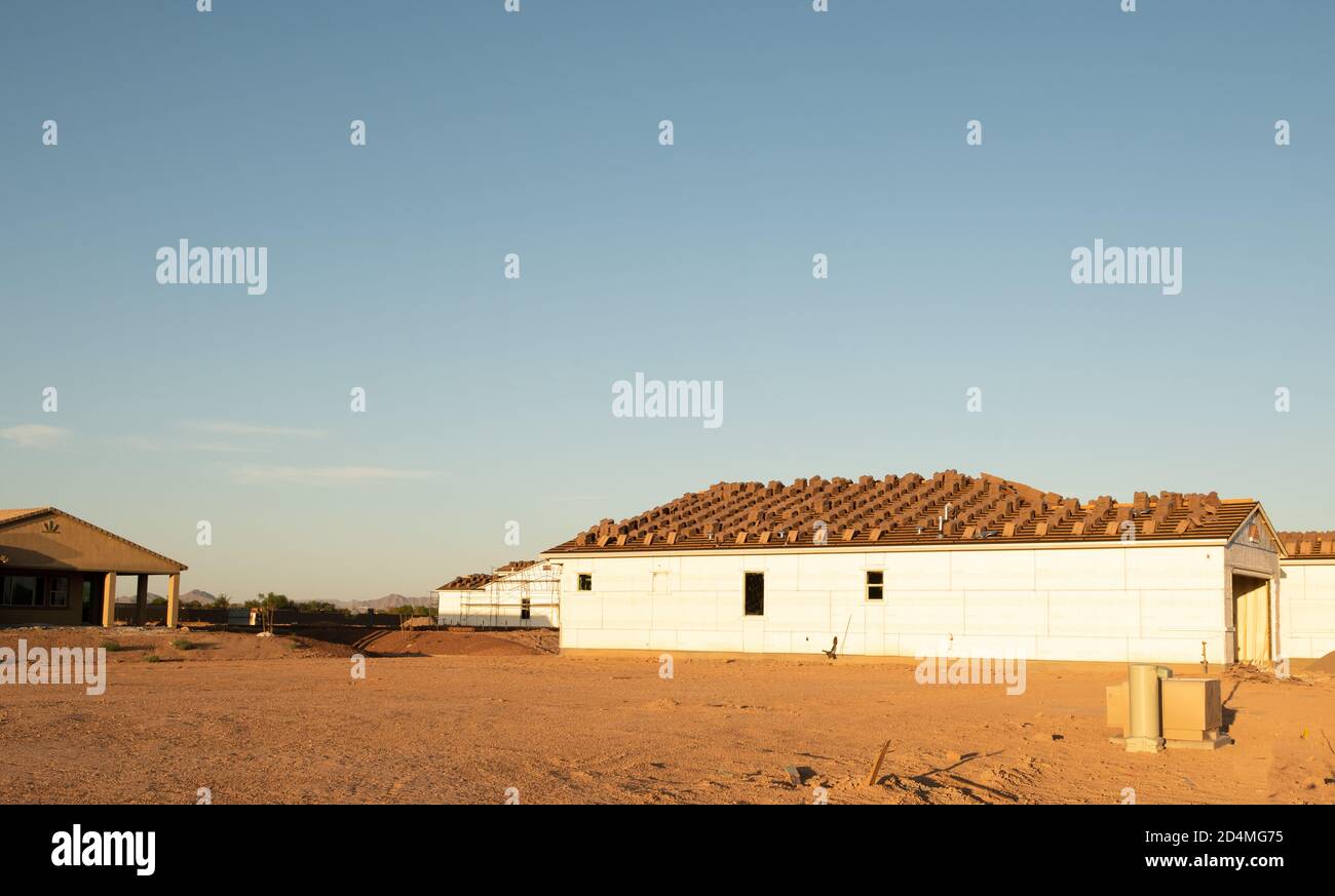 An unfinished house with roofing tiles stacked on the roof ready for ...