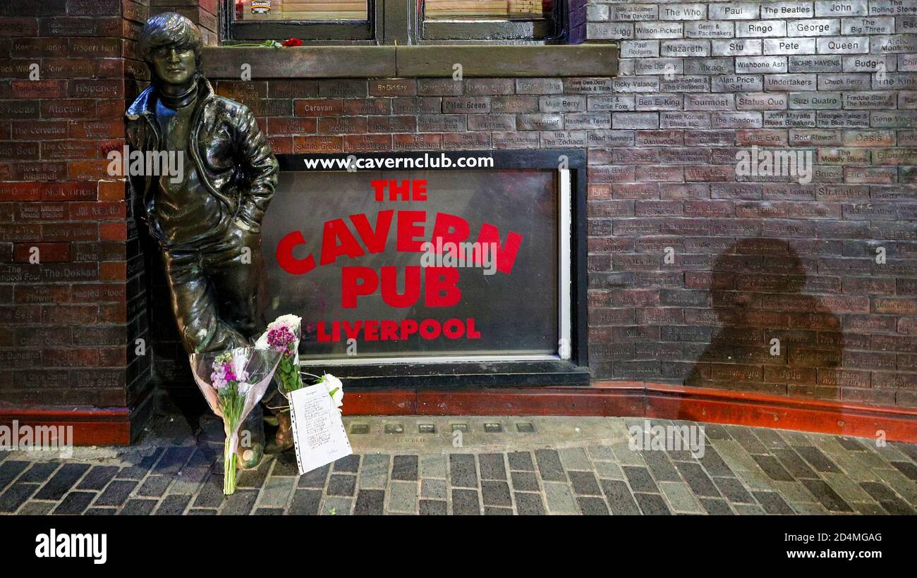 Flowers are left by a statue of John Lennon in Mathew Street, Liverpool ...