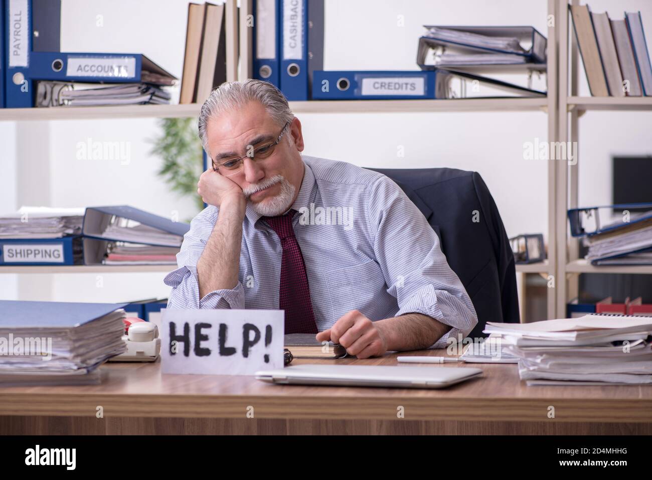 Old employee unhappy with excessive work Stock Photo - Alamy