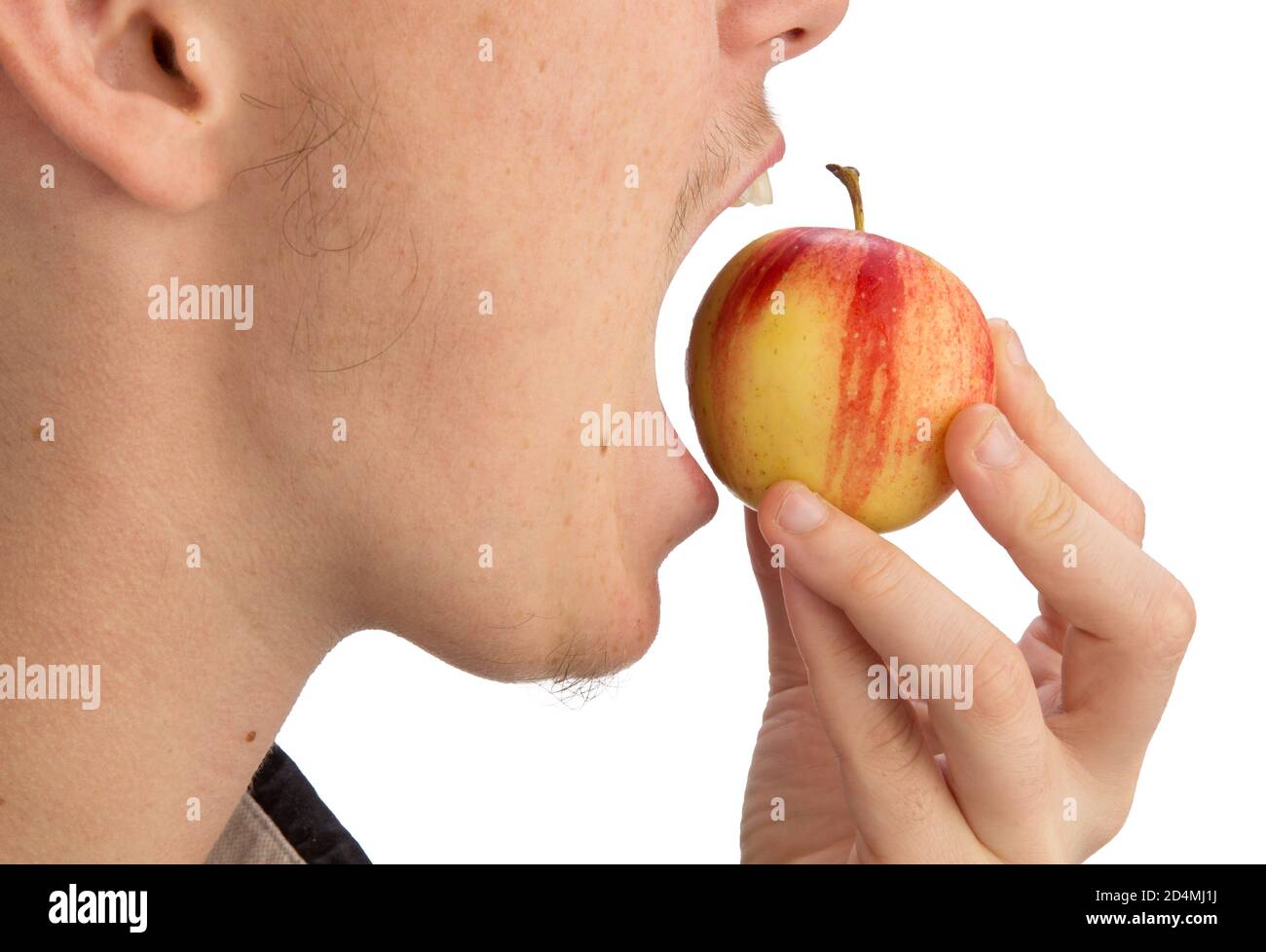 Young man eating an apple on a white background Stock Photo - Alamy