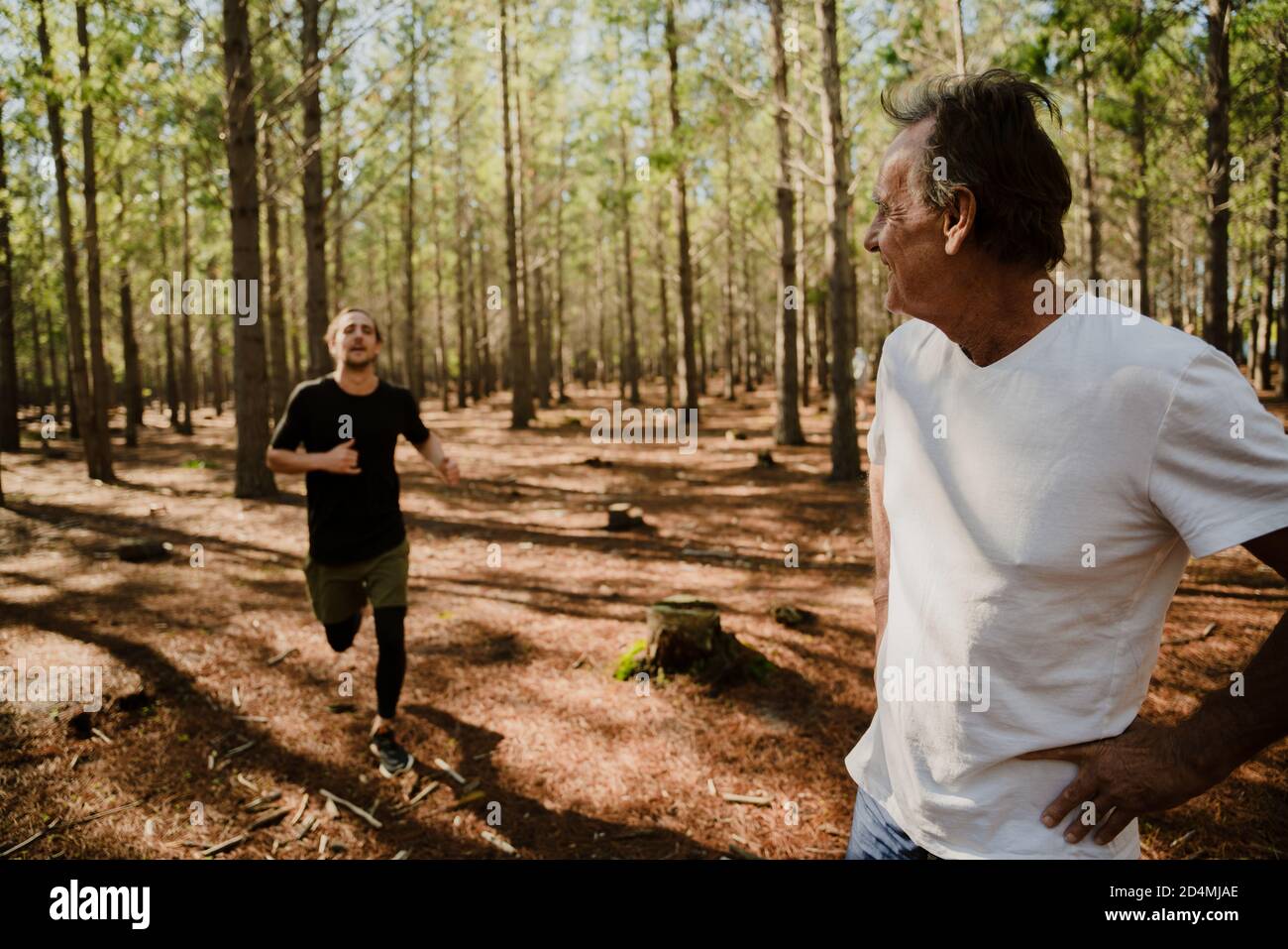 Young father and son running in the forest together, healthy and fit ...