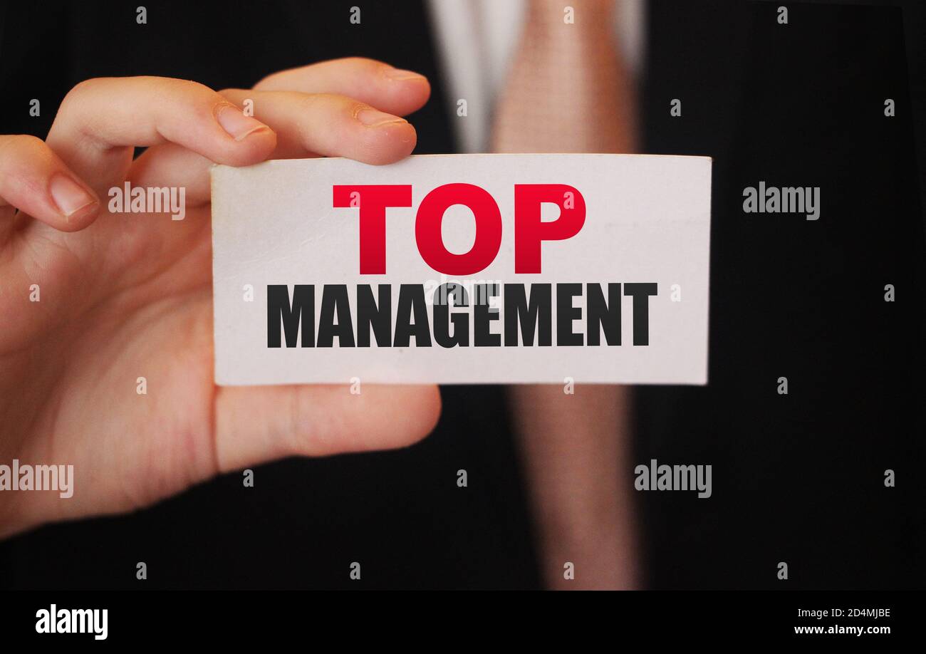 Businessman shows a card with word Top Management. CEO position ...