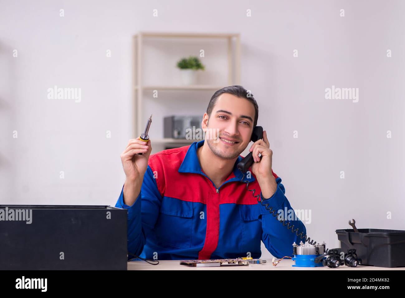Young male repairman repairing computer PC Stock Photo - Alamy