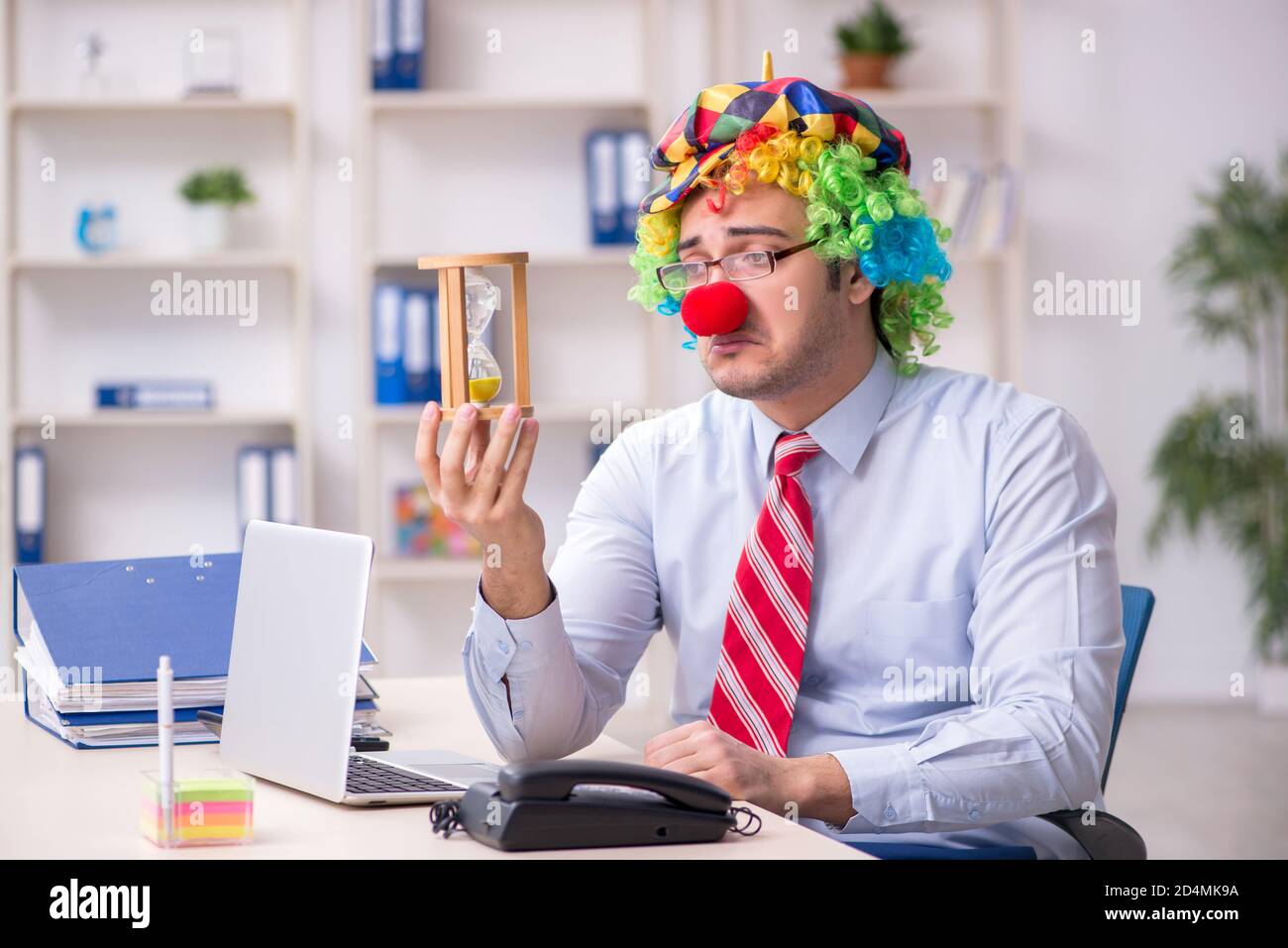 Funny employee clown working in the office room Stock Photo - Alamy