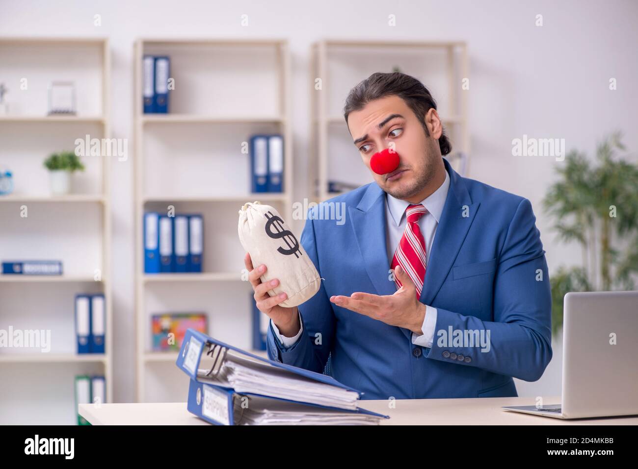 Funny employee clown working in the office room Stock Photo - Alamy