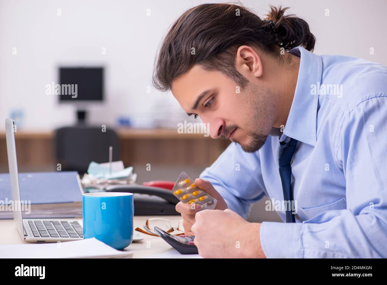 Sick male employee suffering at the workplace Stock Photo - Alamy