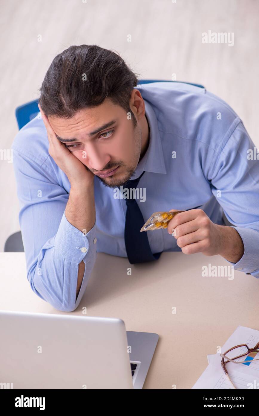 Sick male employee suffering at the workplace Stock Photo - Alamy