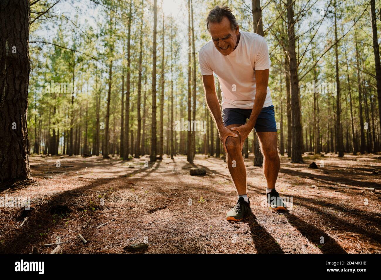 Fit and healthy elderly male injured knee while running in the woods ...