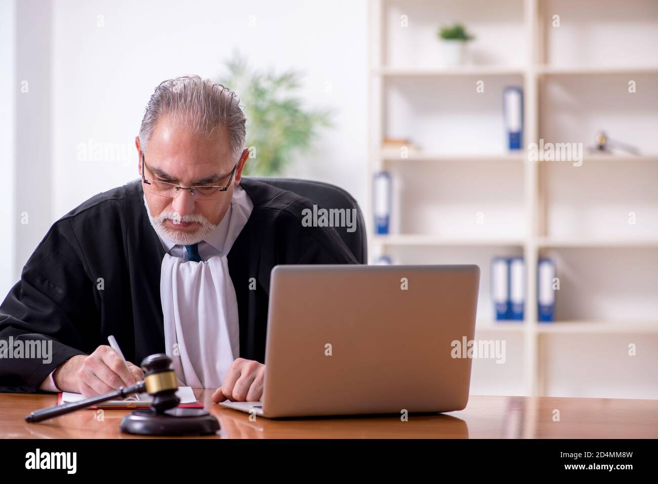 Old male judge working in the courthouse Stock Photo - Alamy