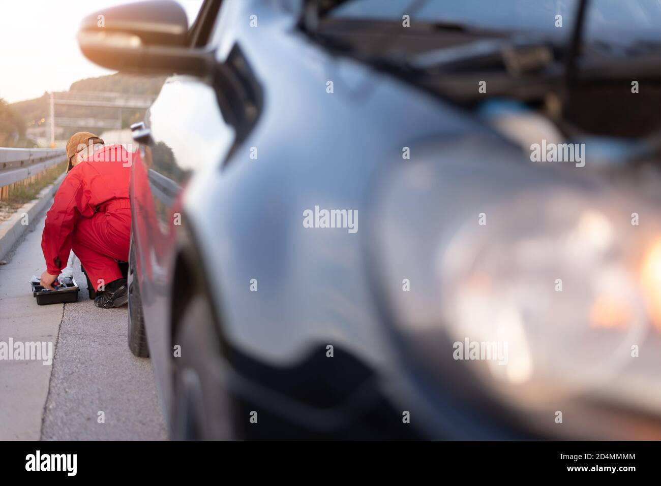 Emergency roadside assistance, road assistance worker in uniform trying ...