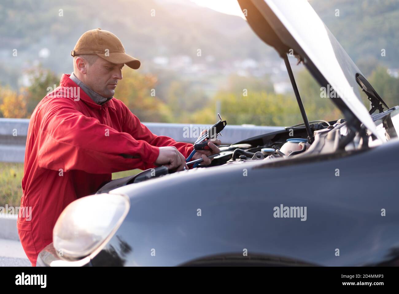 Emergency roadside assistance, road assistance worker in uniform trying ...