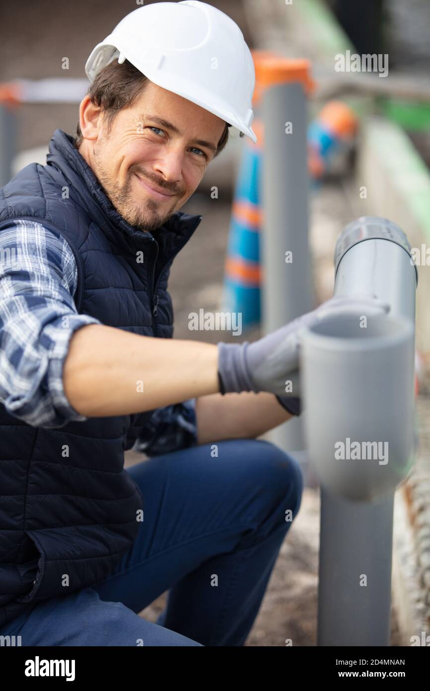portrait of plumber with pipes on construction site Stock Photo - Alamy