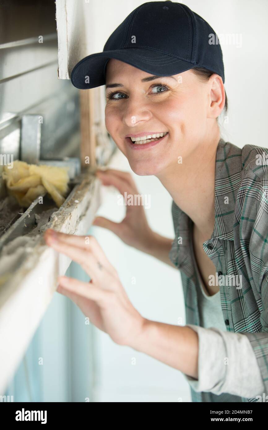 happy female builder repairs the windows Stock Photo - Alamy