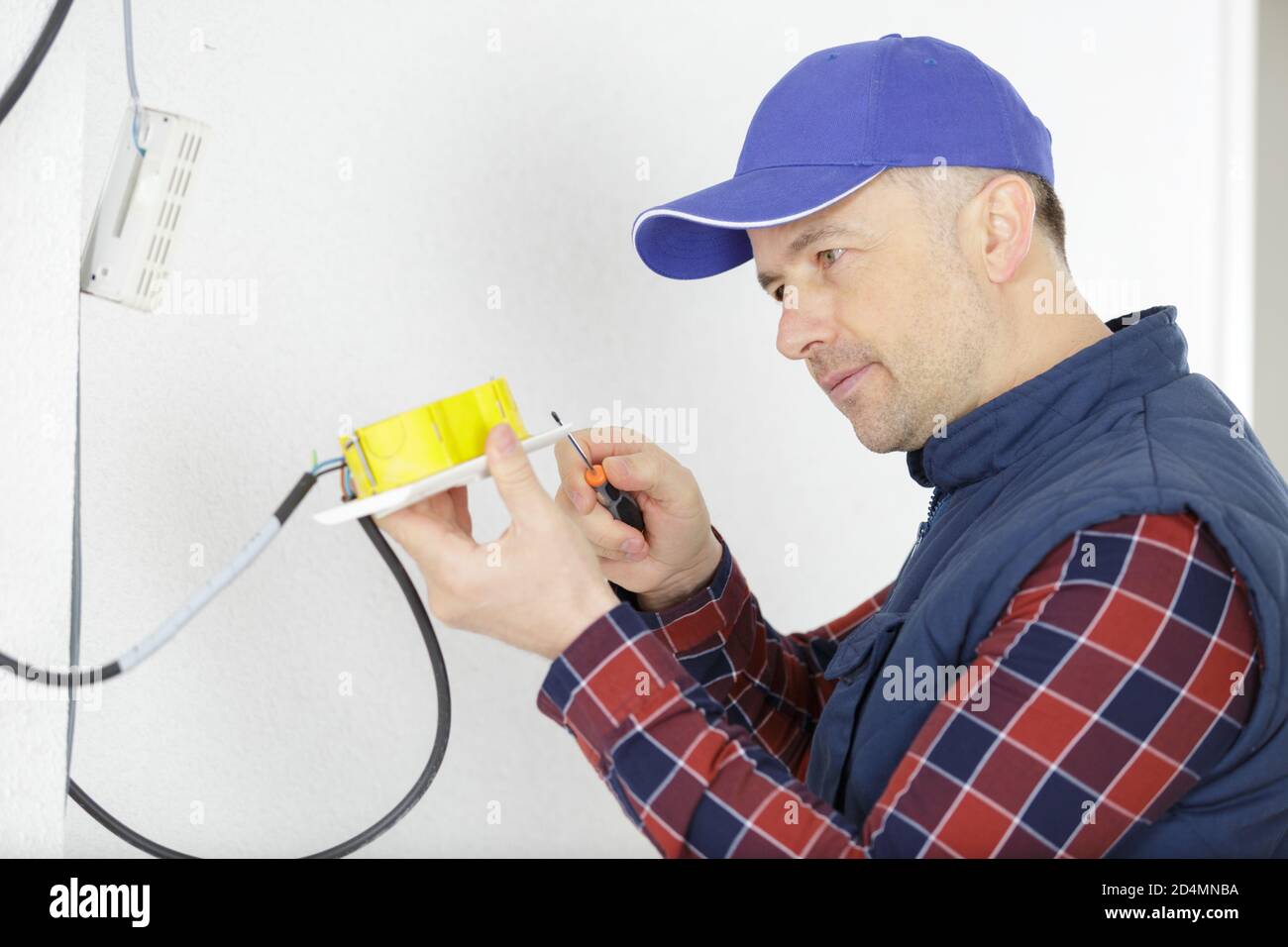worker trying to install wires on the wall Stock Photo - Alamy